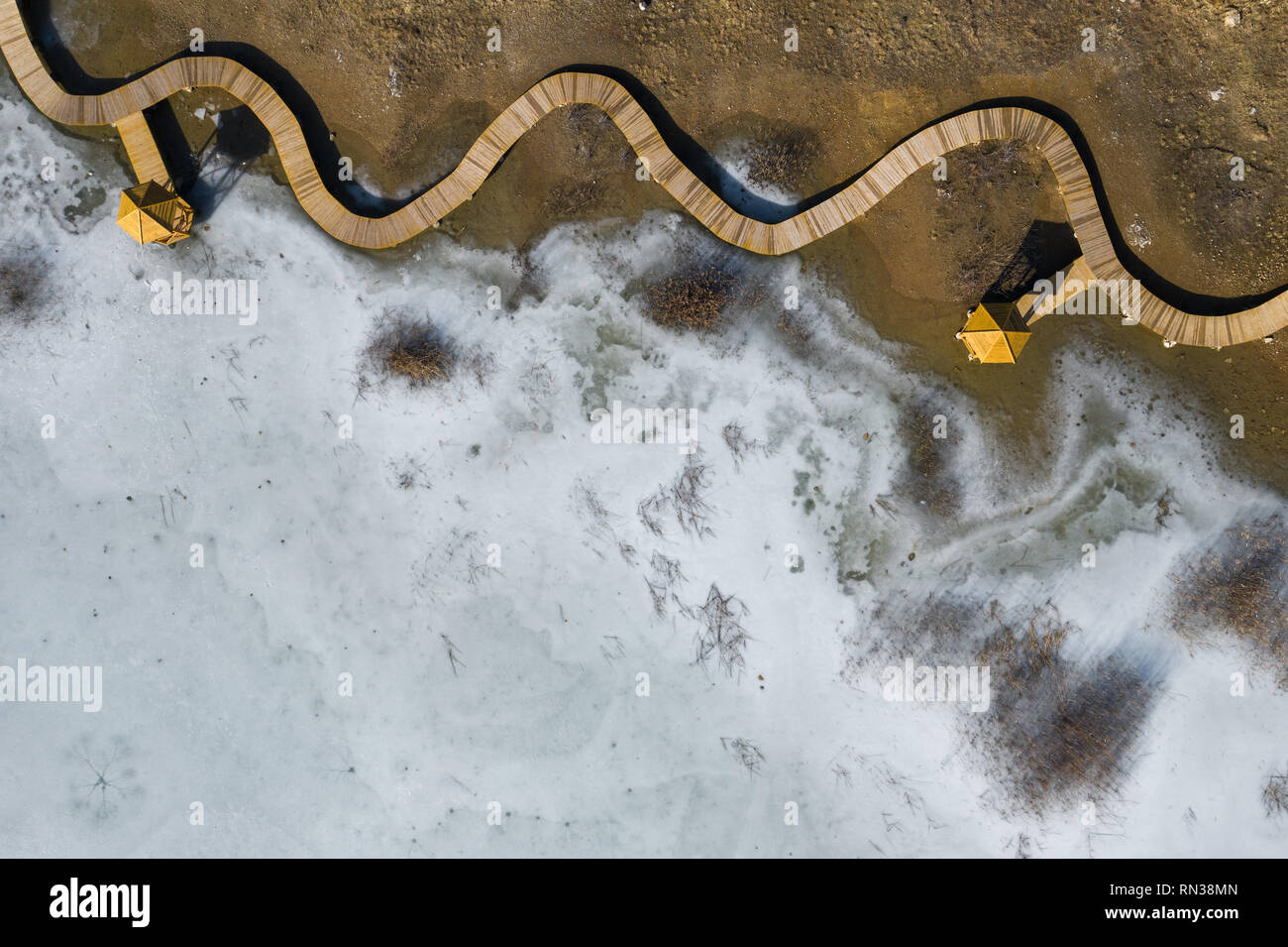 Aerial view of the winter frozen lake with wooden piers from above ...