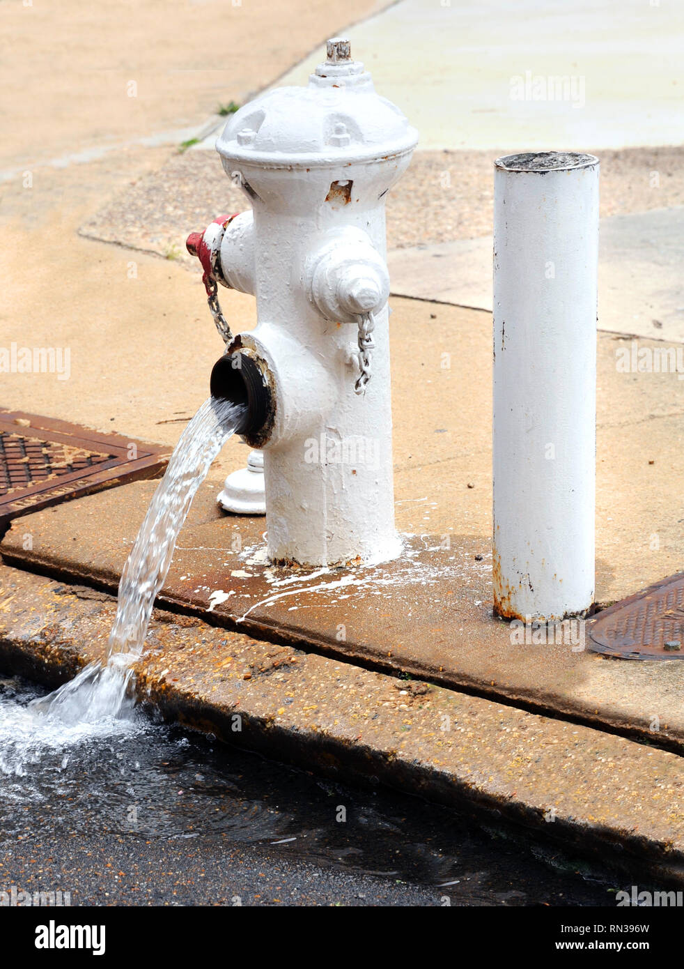 Open water hydrant allows water to gush into the city street in a small ...