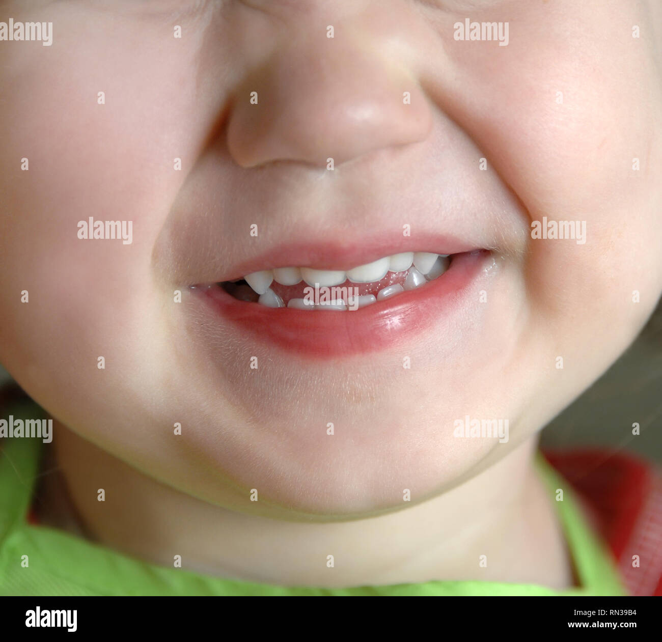 Image shows extreme closeup of a little girl who is smiling and happy ...