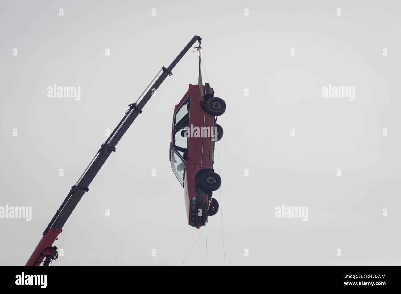Car hanging from a crane before being dropped to the ground before a ...