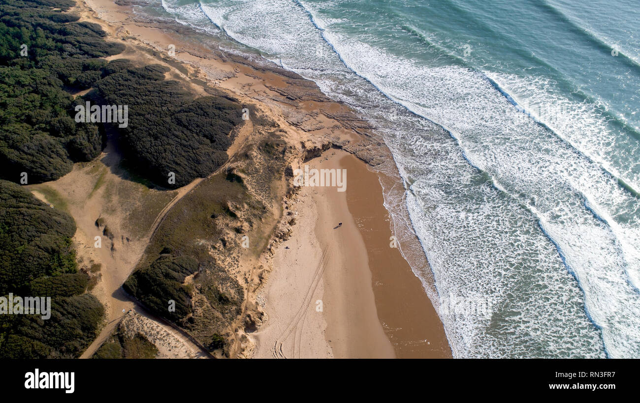 Aerial photo of two people walking on a wild beach in Vendee, France ...