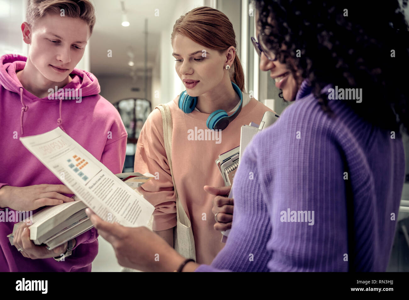Student smiling while explaining difficult material to her friends ...