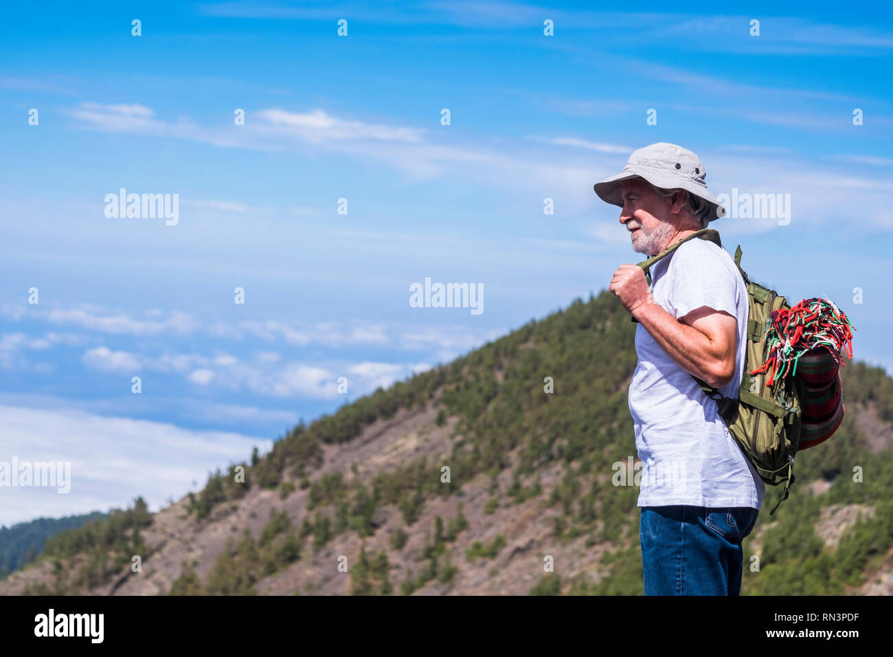 Lonely adult aged trekker with backpack standing and looking at the ...