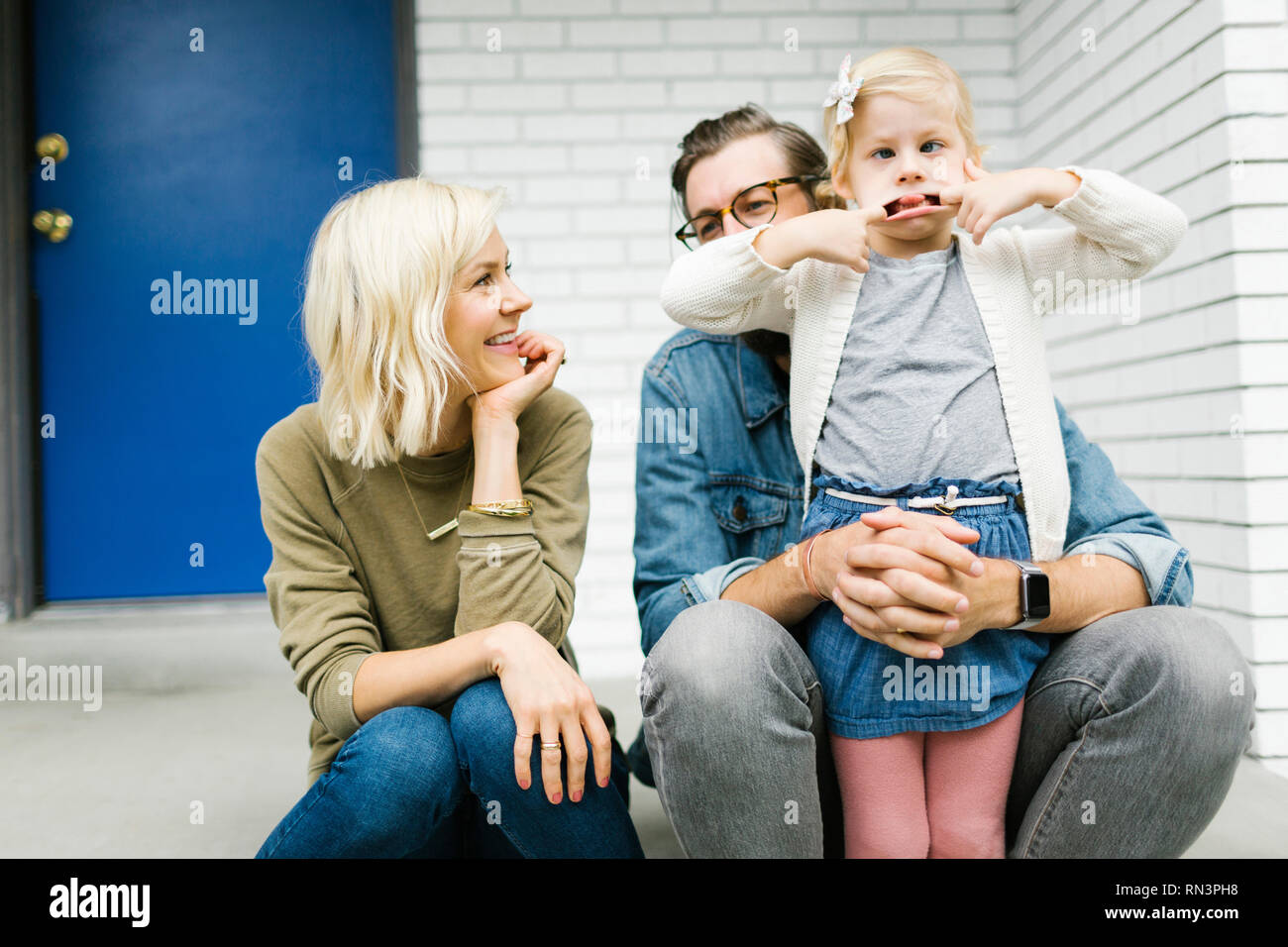 Girl making a face with her parents Stock Photo - Alamy