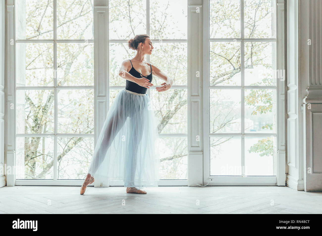 Young classical ballet dancer woman in dance class. Beautiful graceful ballerina practice ballet ...