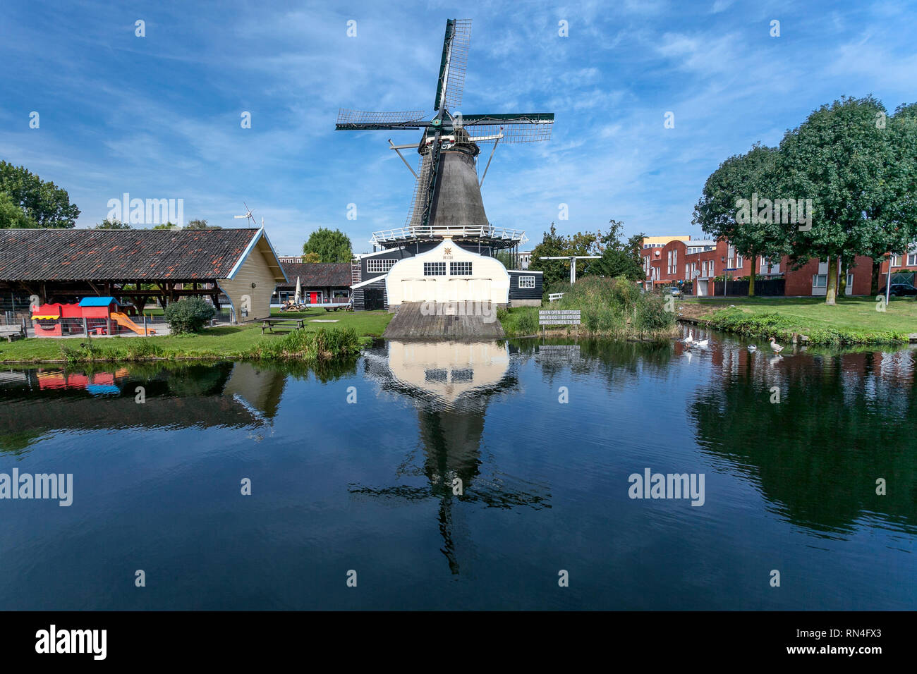 Windmill and mirrored in the water in front Stock Photo - Alamy