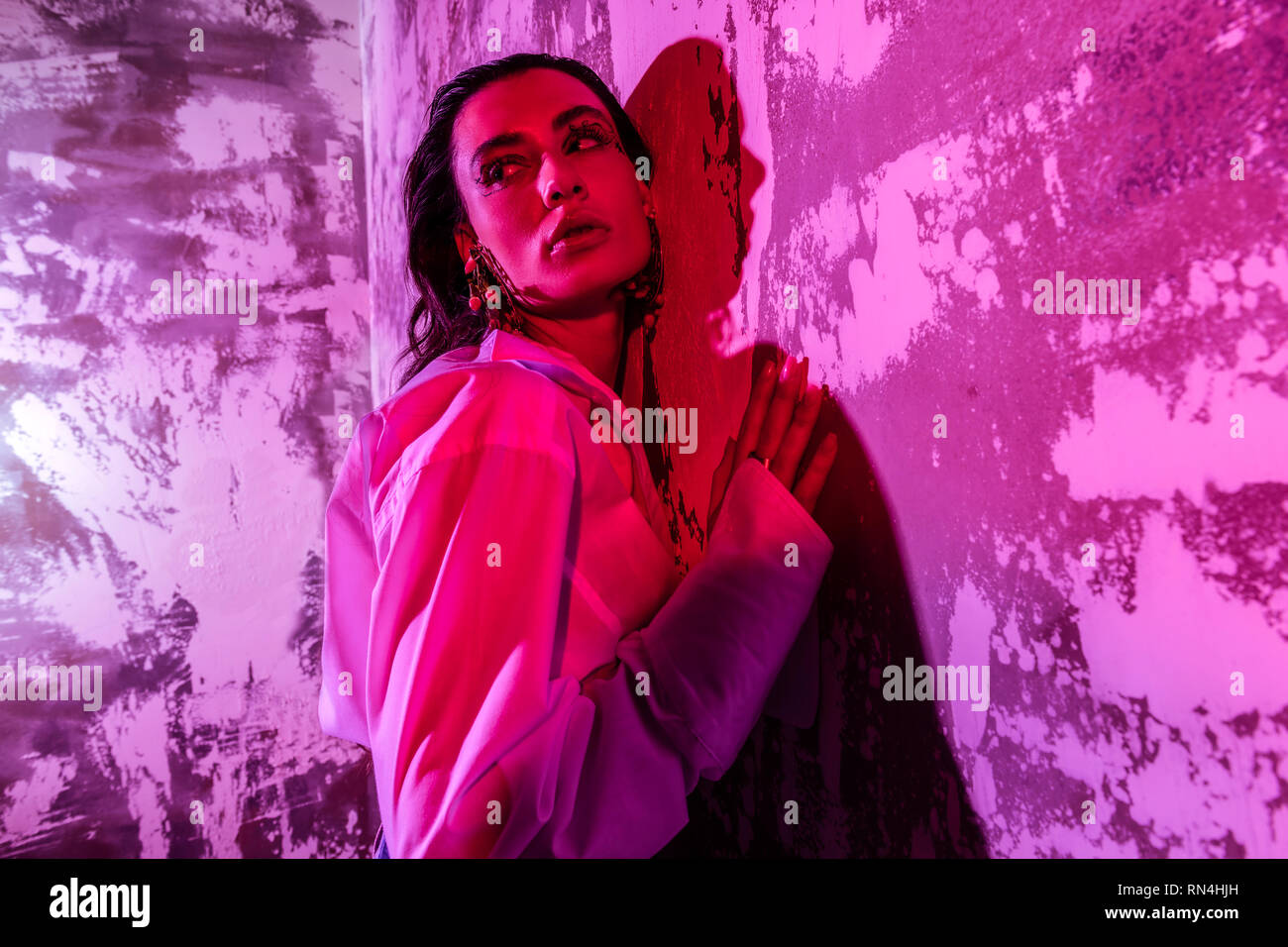 Nice pretty young woman touching the wall Stock Photo - Alamy