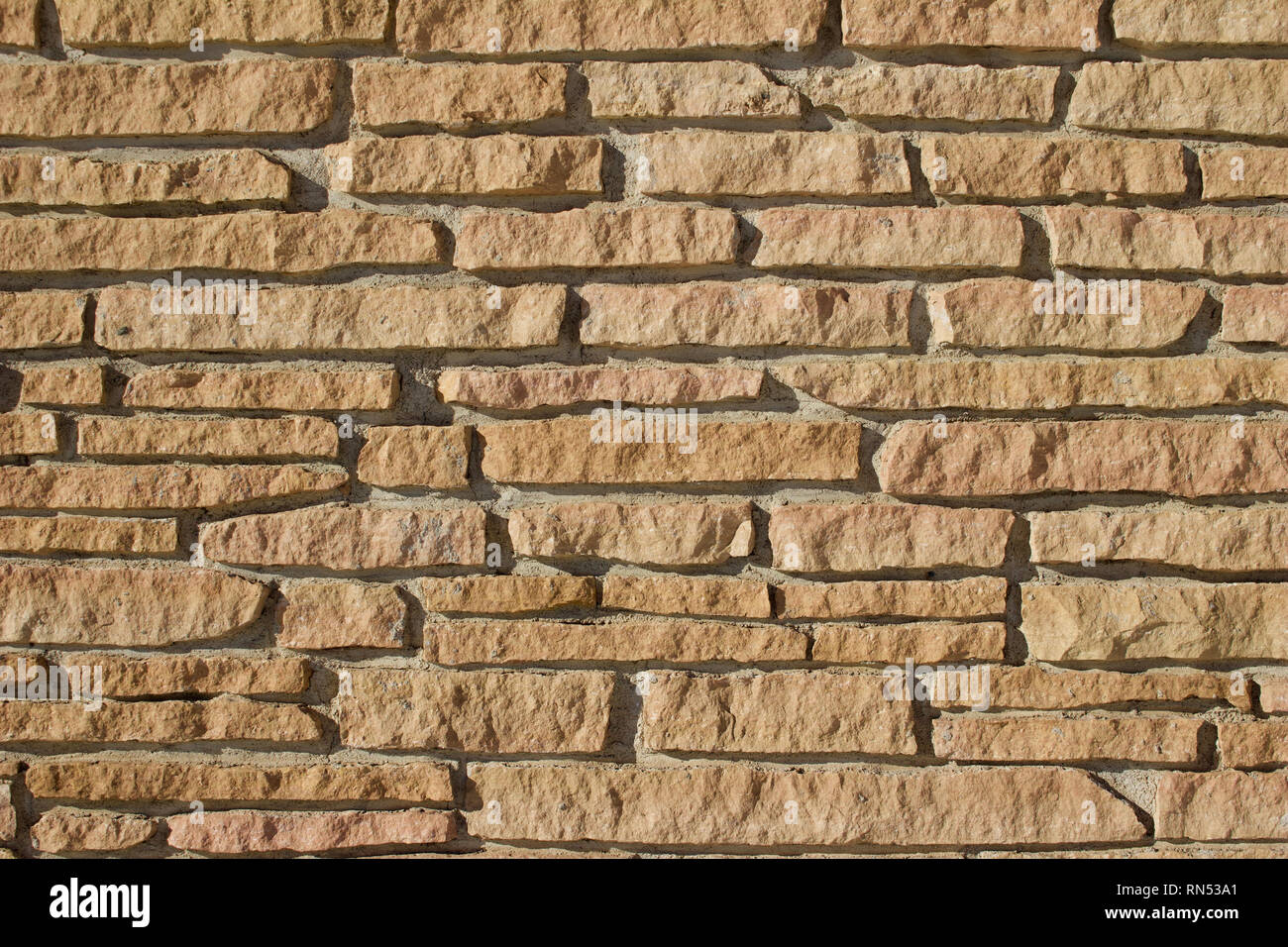 Very rustic looking tan colored stone brick wall with rugged cut stones ...