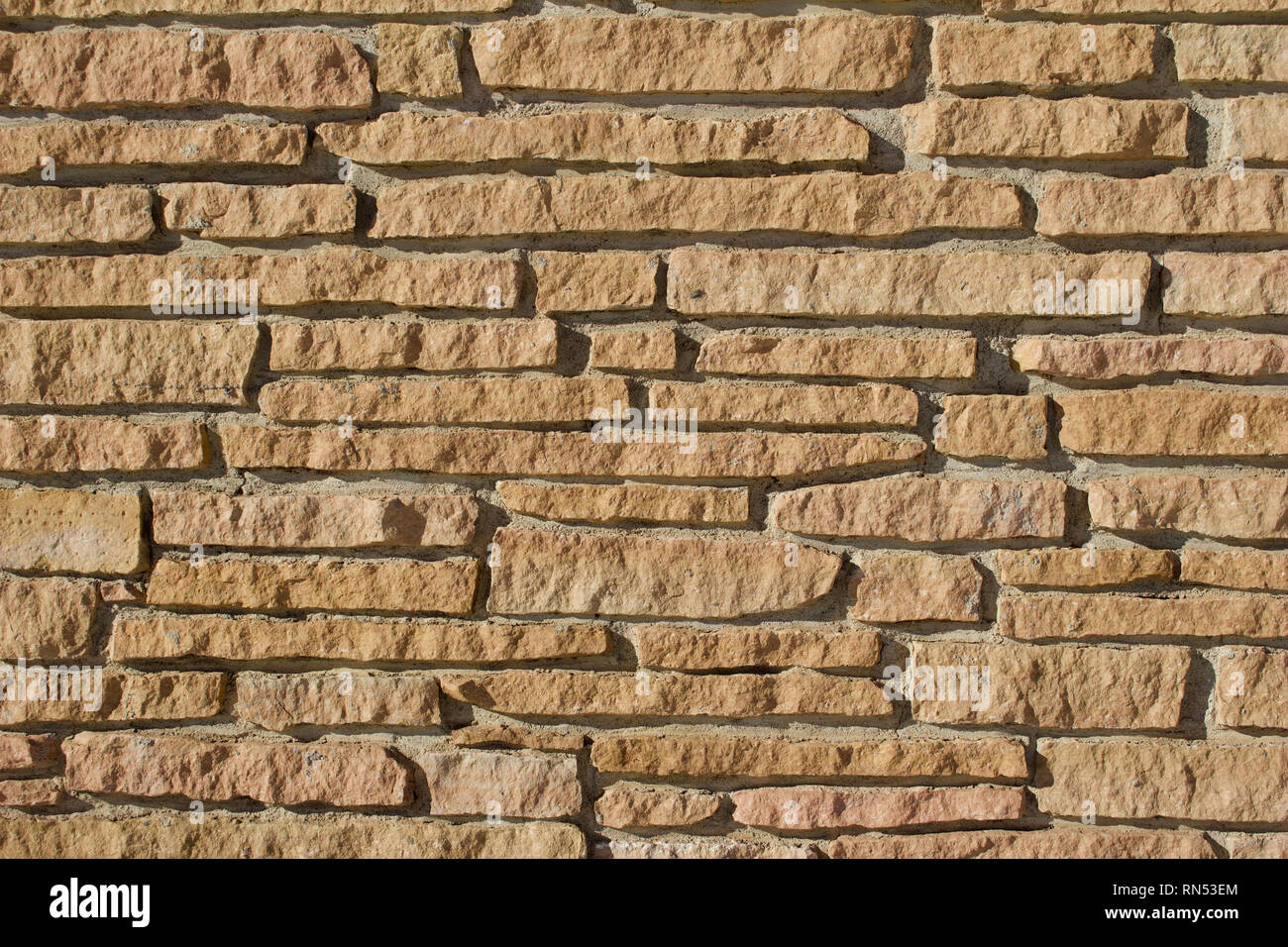 Very rustic looking tan colored stone brick wall with rugged cut stones ...