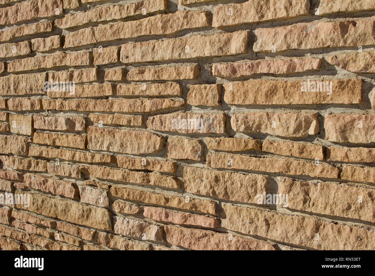Very rustic looking tan colored stone brick wall with rugged cut stones ...