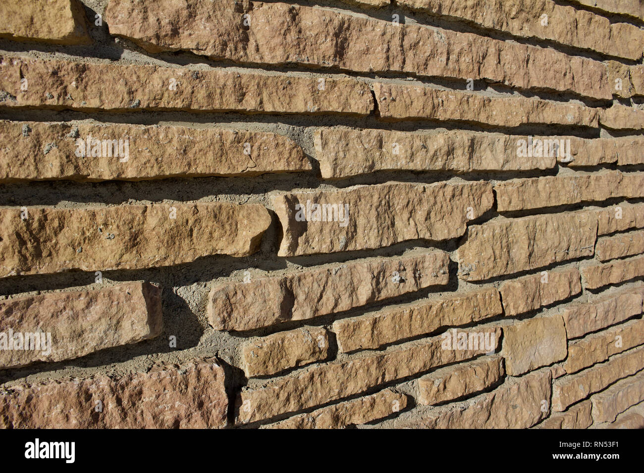 Very rustic looking tan colored stone brick wall with rugged cut stones ...