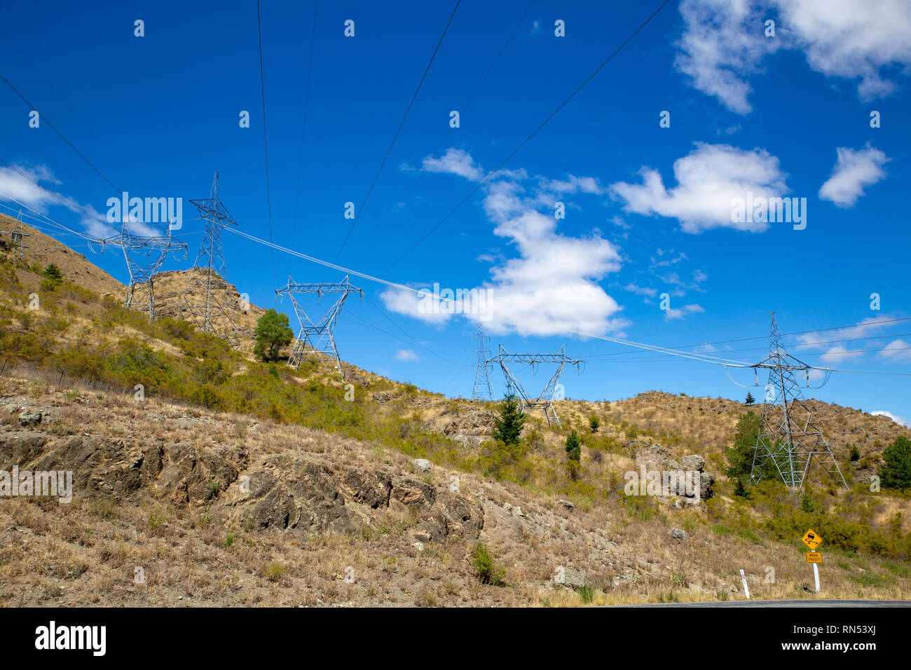 Huge pylons line the hill around the side of Benmore Dam, New Zealand ...