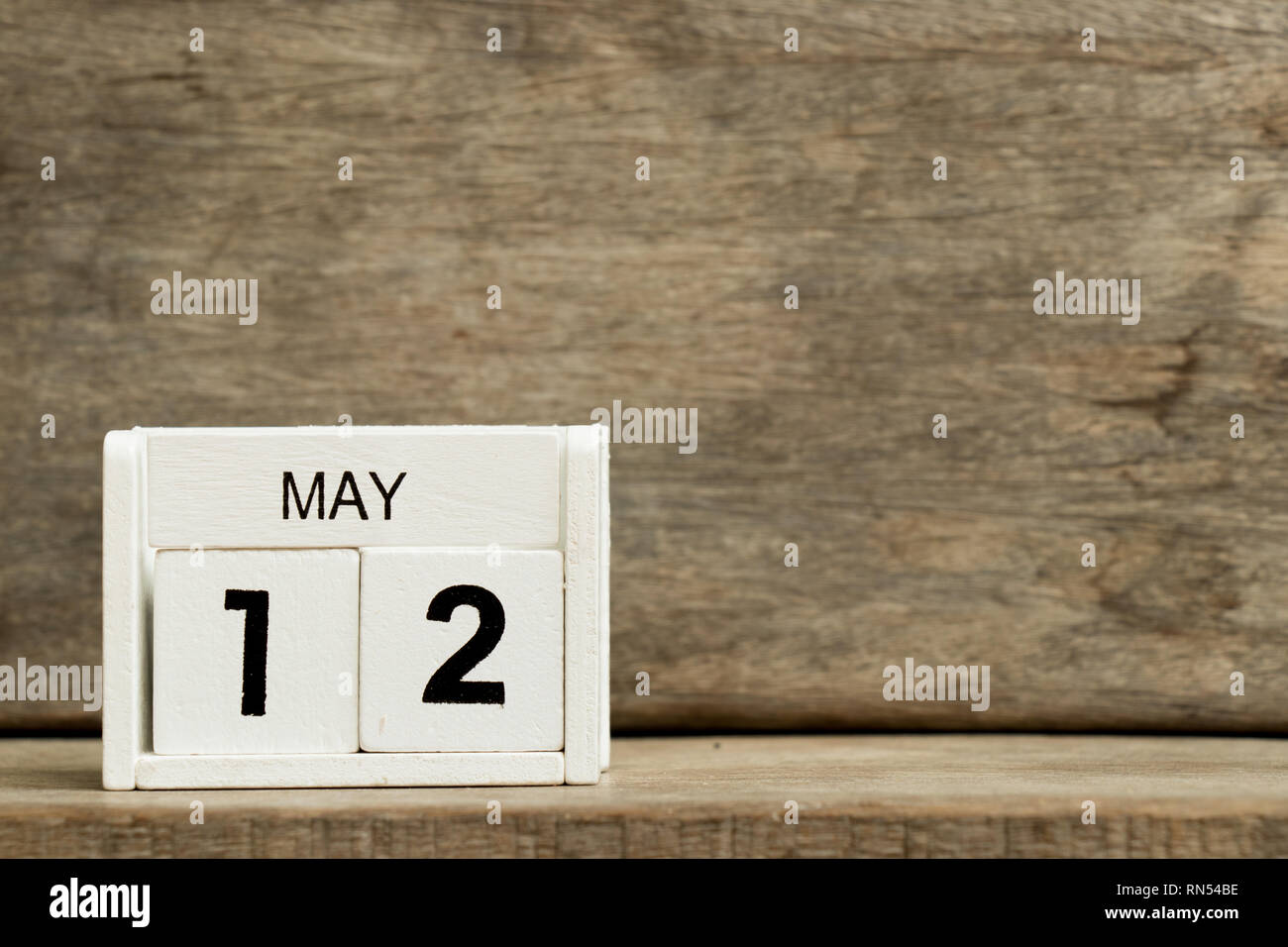 White block calendar present date 12 and month May on wood background ...