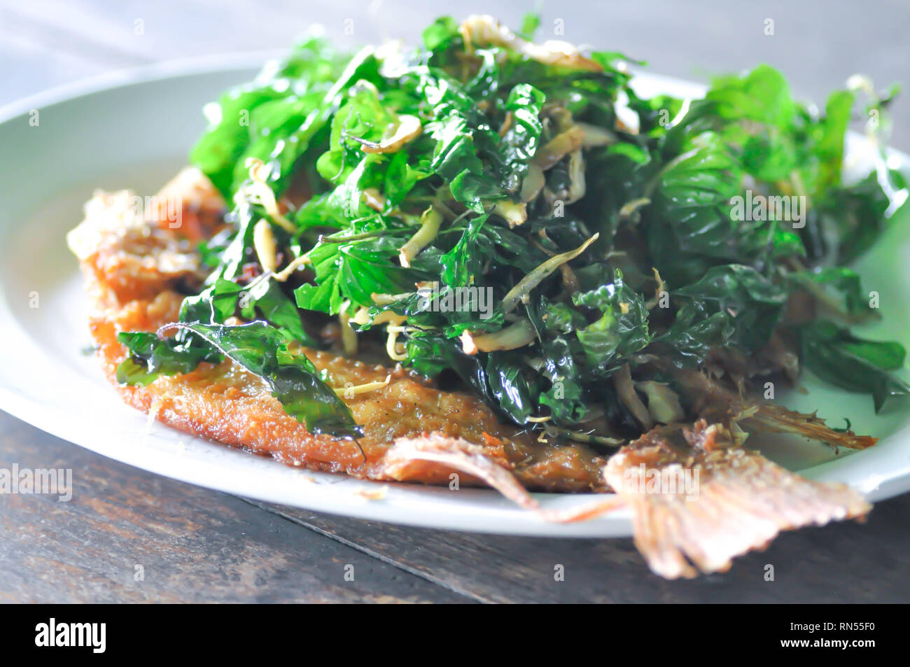 deep fried fish and fried holy basil topping Stock Photo - Alamy
