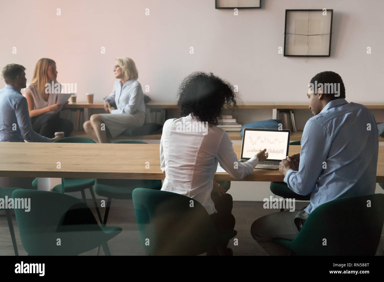 Team members working together view through glass wall Stock Photo - Alamy