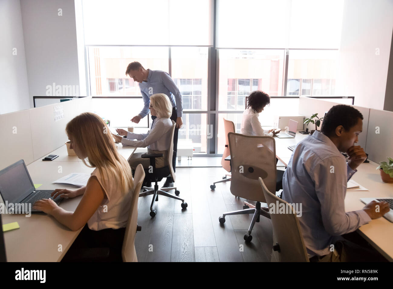 Five different employees working in coworking space Stock Photo - Alamy