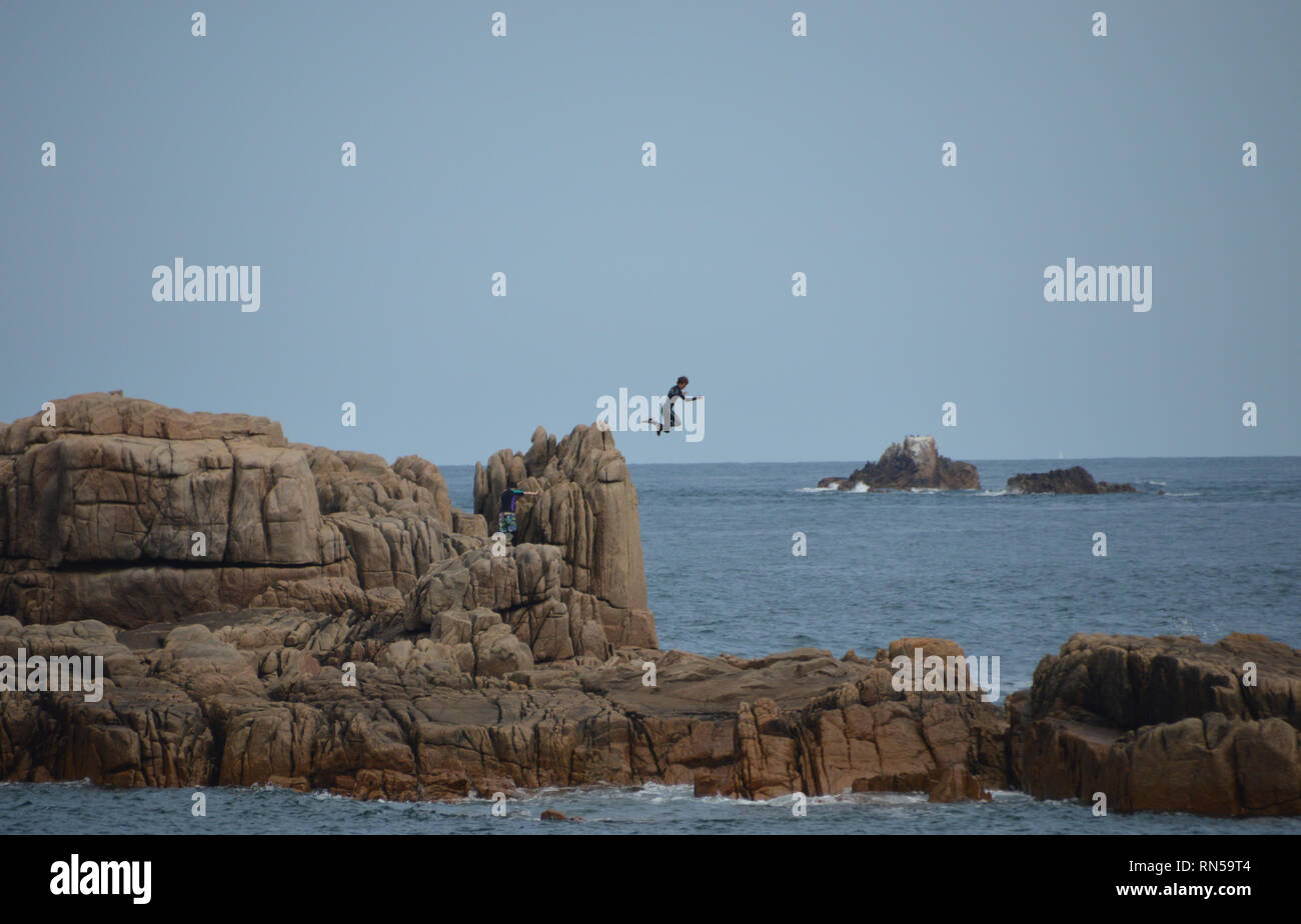 Young Men Jumping off Cliffs into the Sea 'Coasteering' seen from the ...