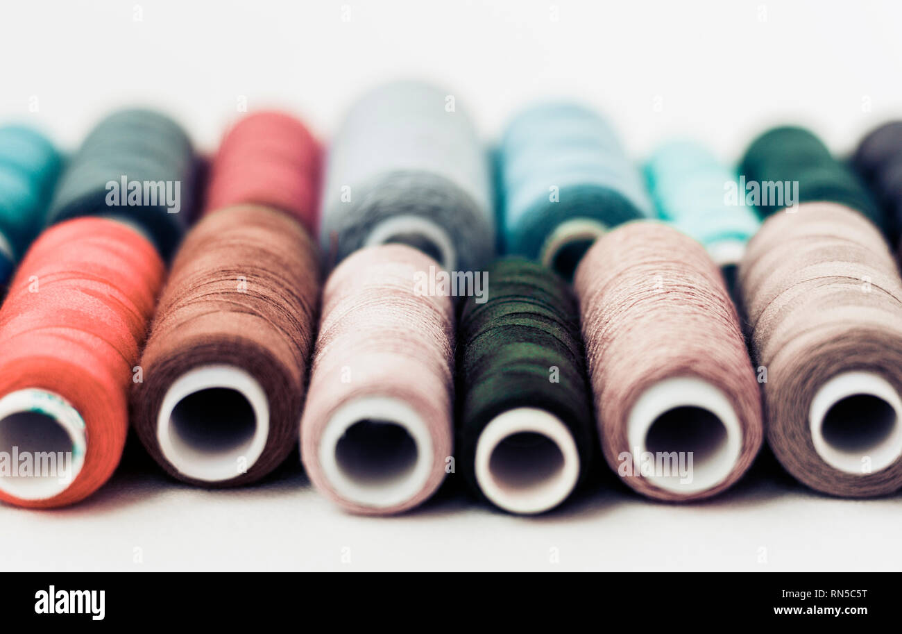 Colored sewing thread coils on white background with copy space for ...