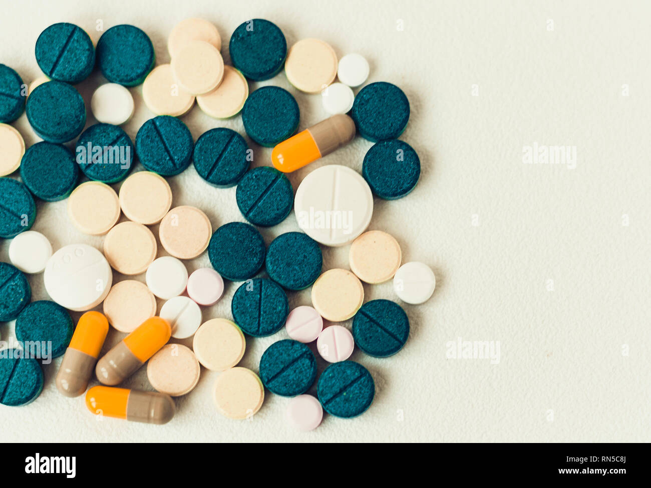 Medicine green, pink and yellow pills or capsules on white background ...