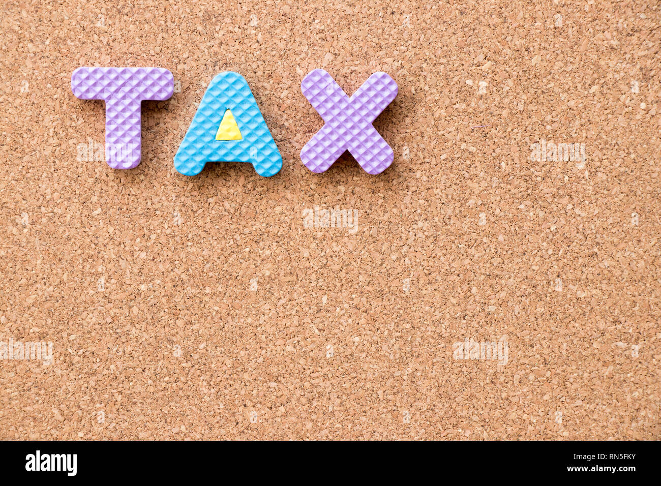 Color toy foam alphabet in word tax on cork board background Stock ...