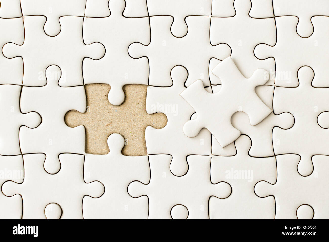 Closed up background of white plain jigsaw wait missing piece to match ...