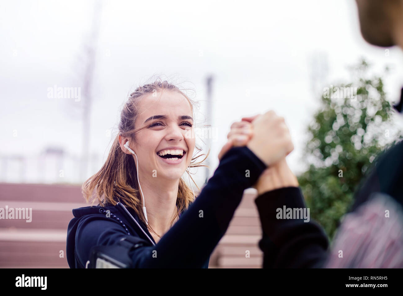 Young woman is shaking the arm of her personal trainer after successful ...