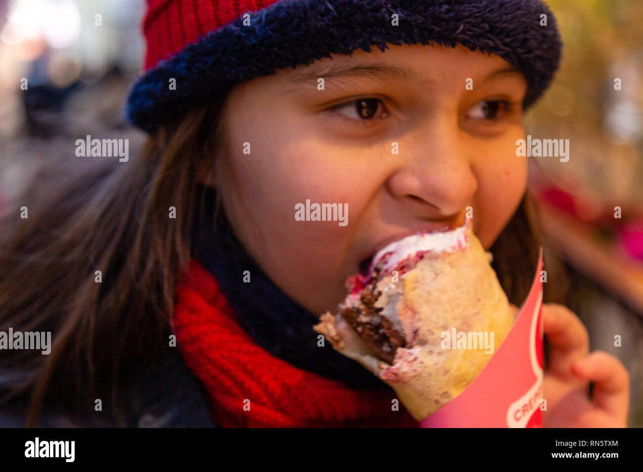 Asian American girl eating crepe Stock Photo - Alamy