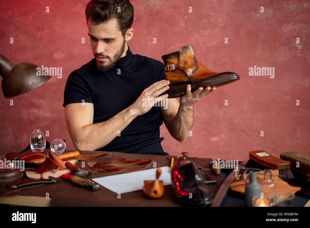 young shoemaker choosing the tool to repair boots, close up photo Stock ...