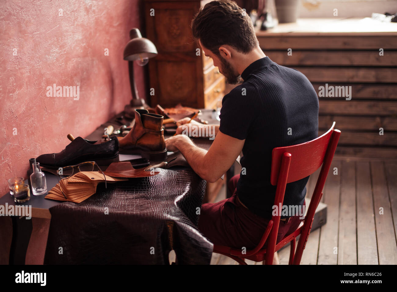 shoemaker fullfilling an order.craftsman executes an order, back view ...