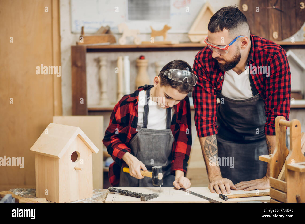Time for family. Dad shows his little son how to make diy birdhouse in ...