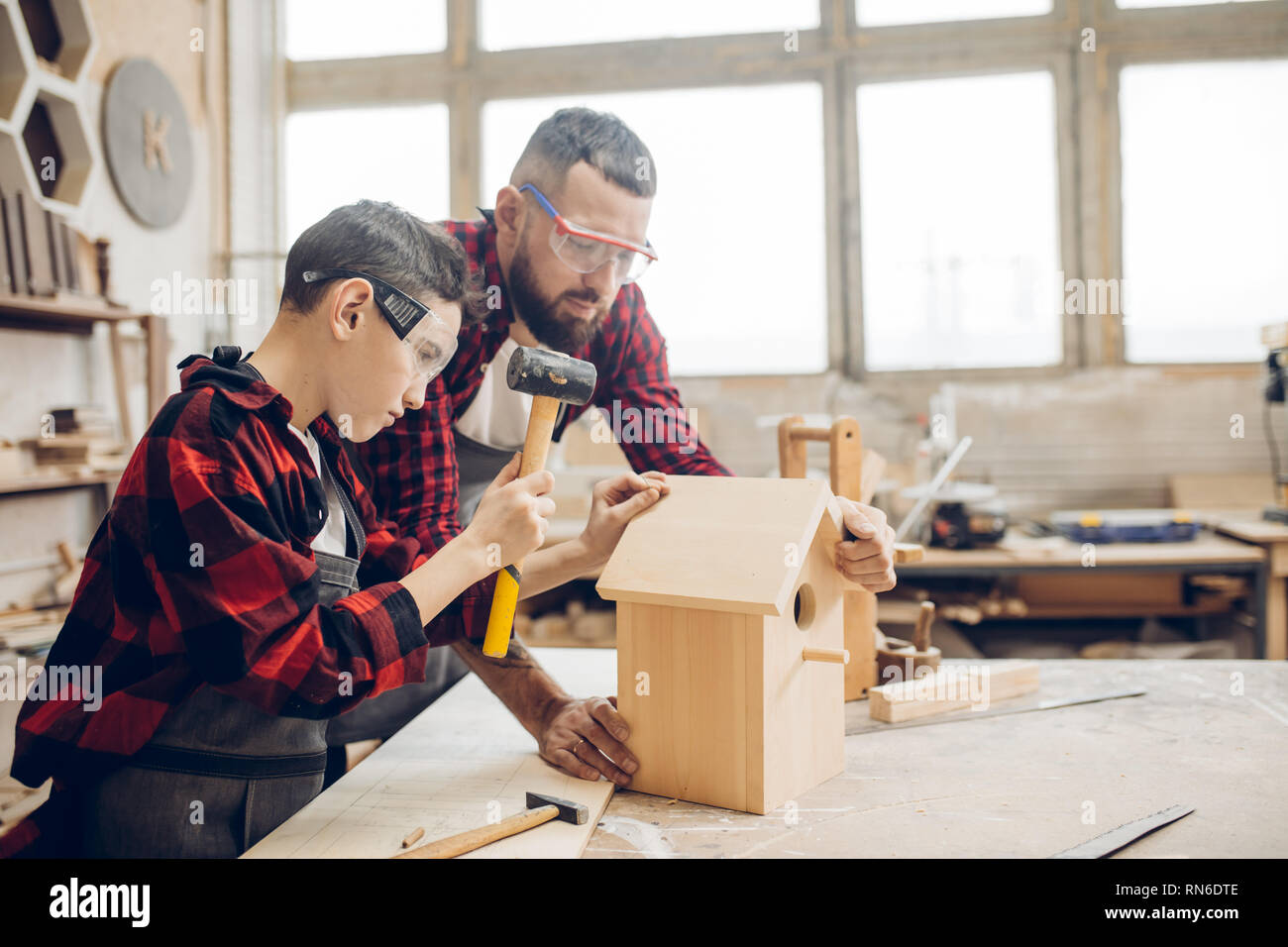 Time for family. Dad shows his little son how to make diy birdhouse in ...