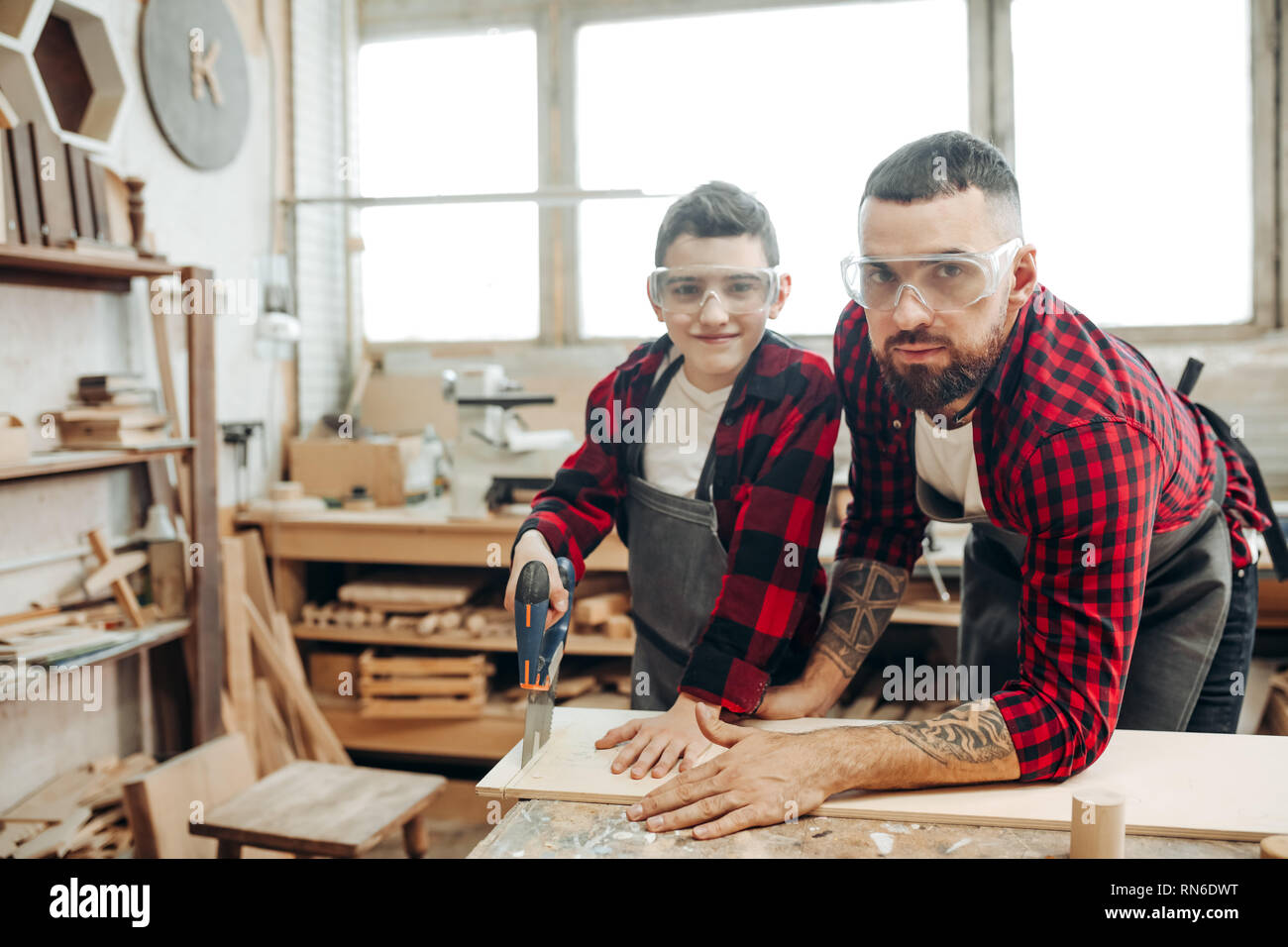 Dad and his son dressed in checkered red shirts and wearing safety ...