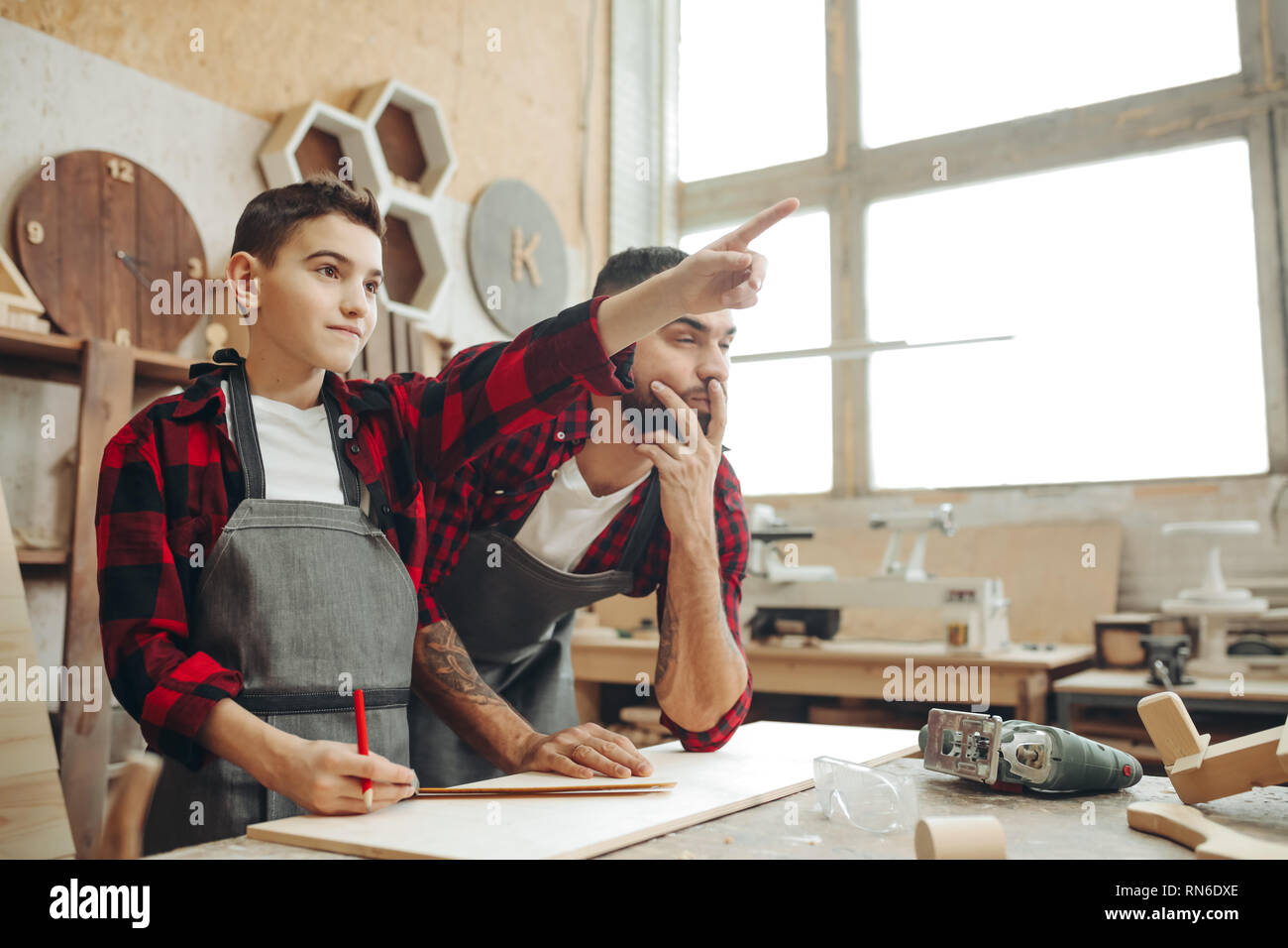 family, carpentry, woodwork and people concept - Male kid pointing with ...