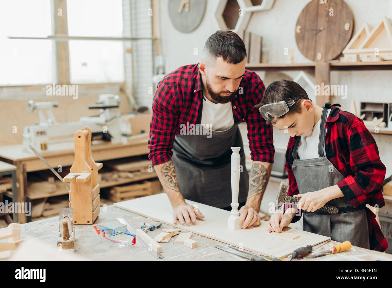 Hardworking little boy is busy taking measure and marking of wooden ...