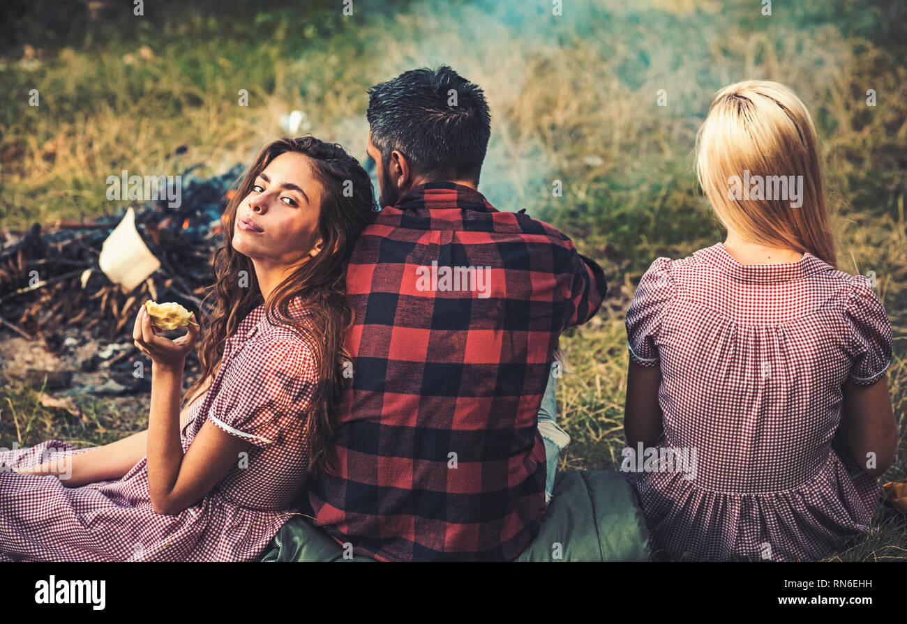 Brunette girl leaning on her boyfriend. Turn back friends sitting on ...