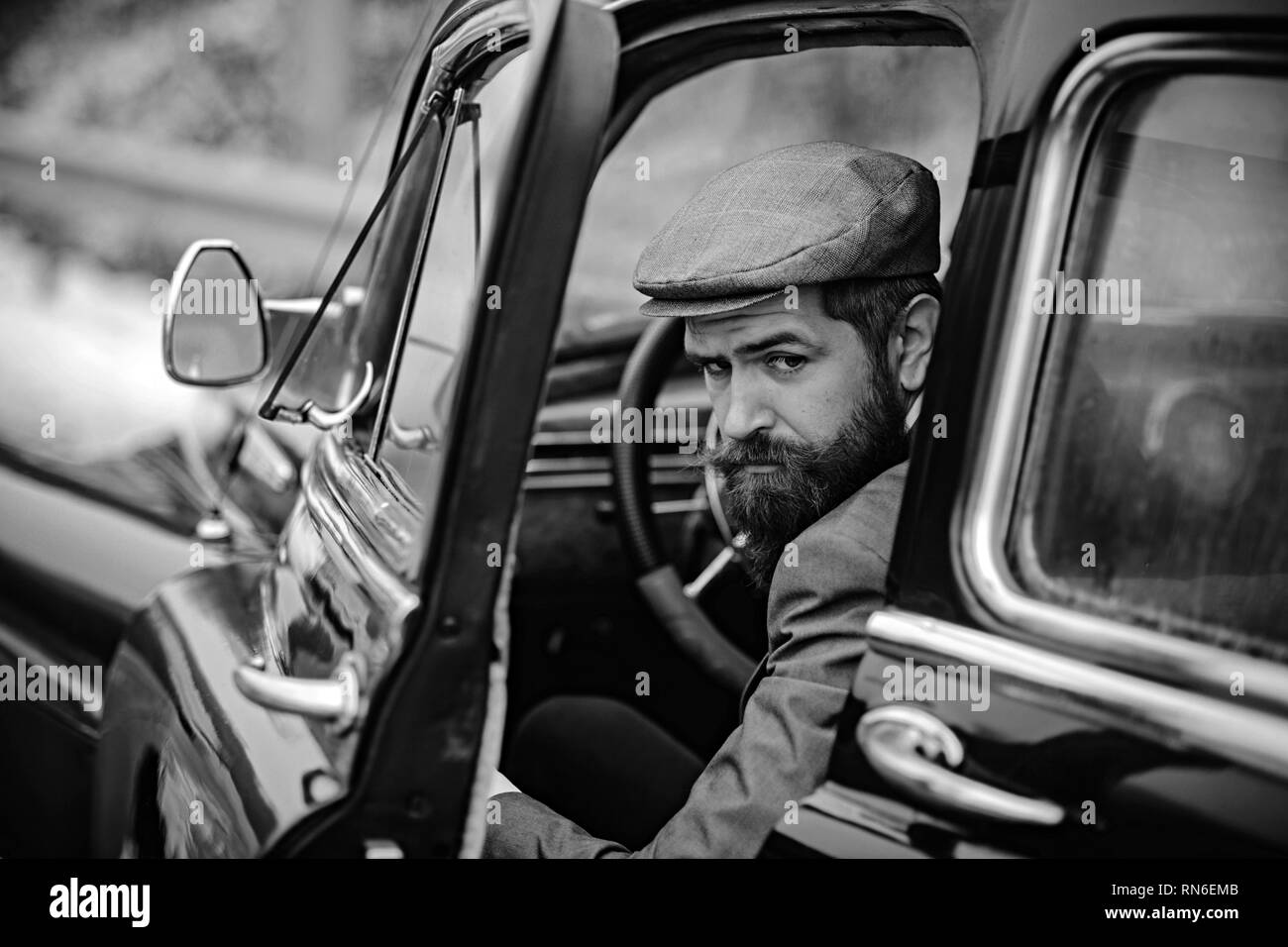 brutal bearded man with a smart mustache brunette sitting in a saloon ...