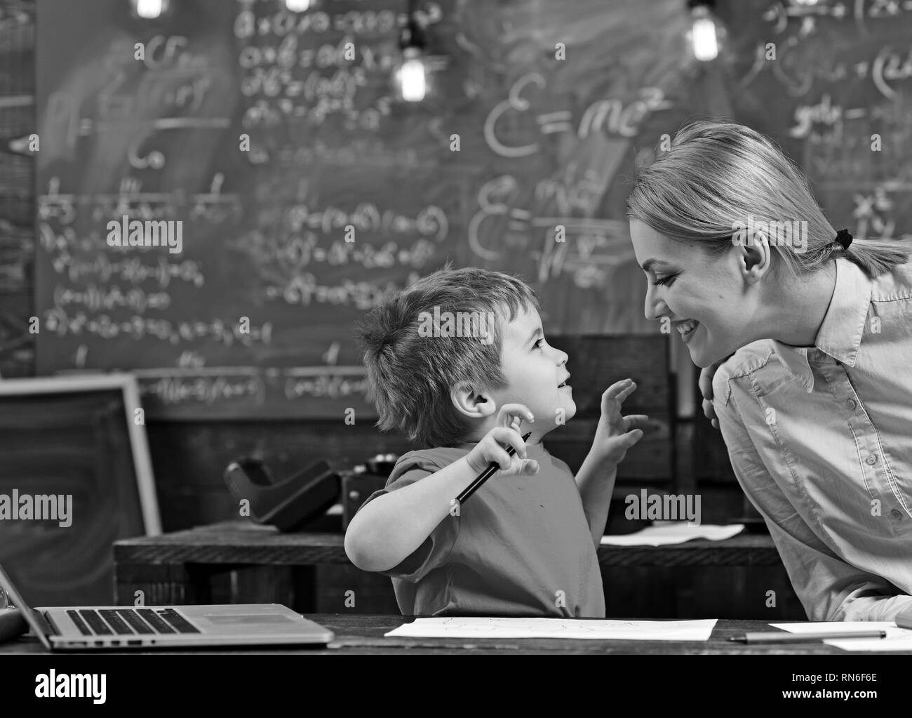 Happy son and mother have lesson in drawing. Boy and woman smile at ...