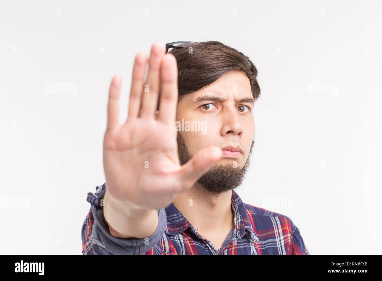 People, expression and gesture concept - young man showing stop gesture ...