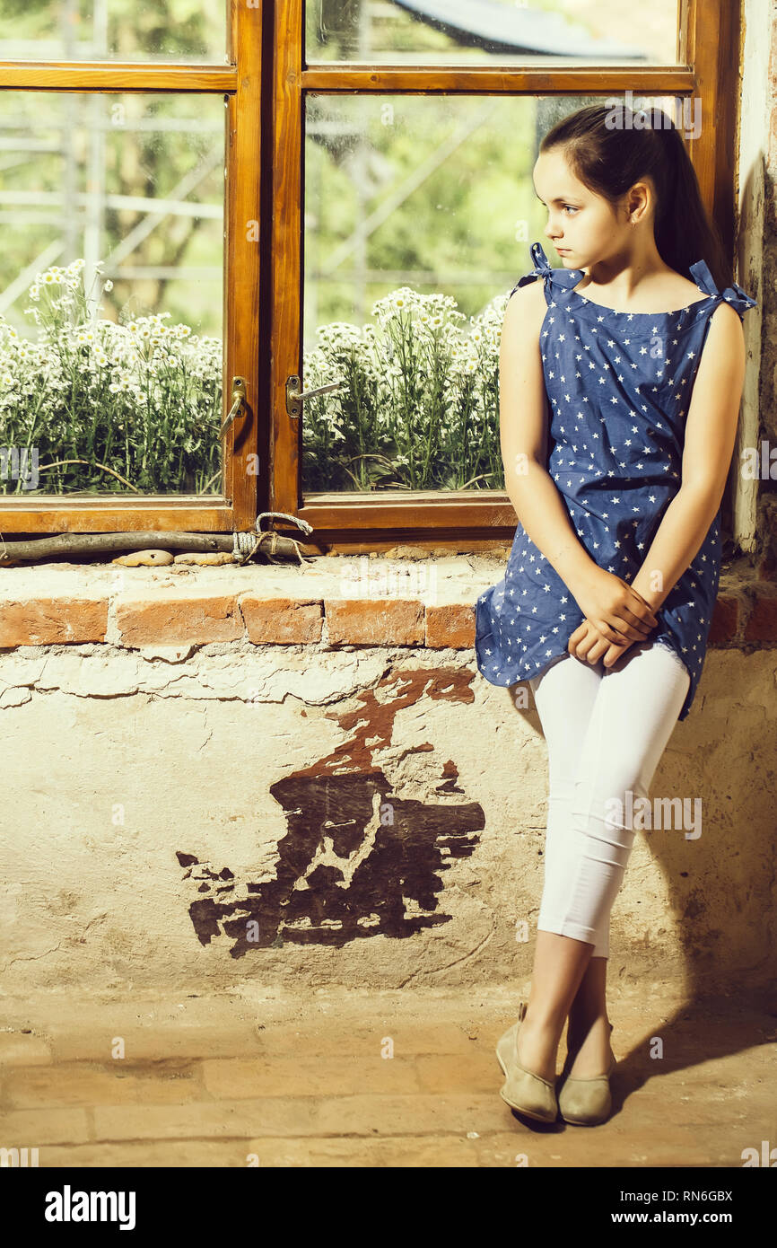 Serious girl sitting near window Stock Photo - Alamy