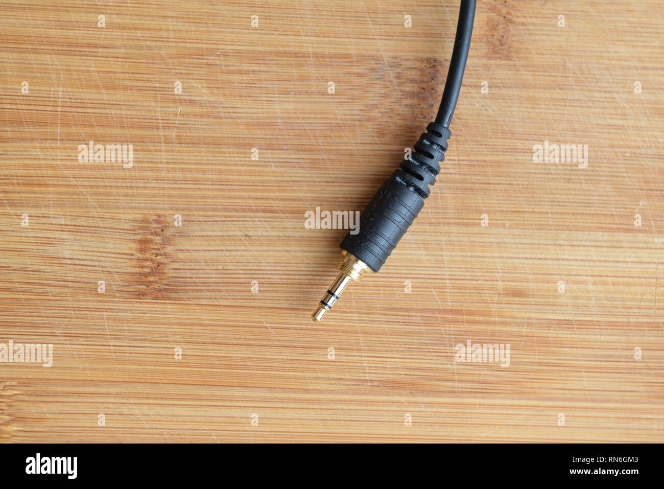golden stereo jack plug on wooden ground Stock Photo - Alamy