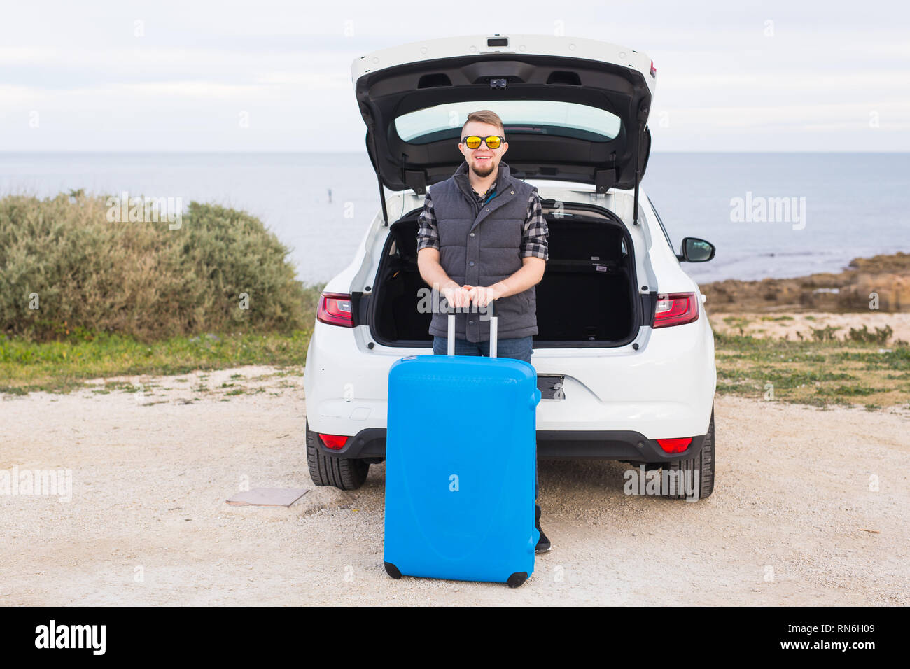 Man standing in back of car smiling and getting ready to go. Young ...