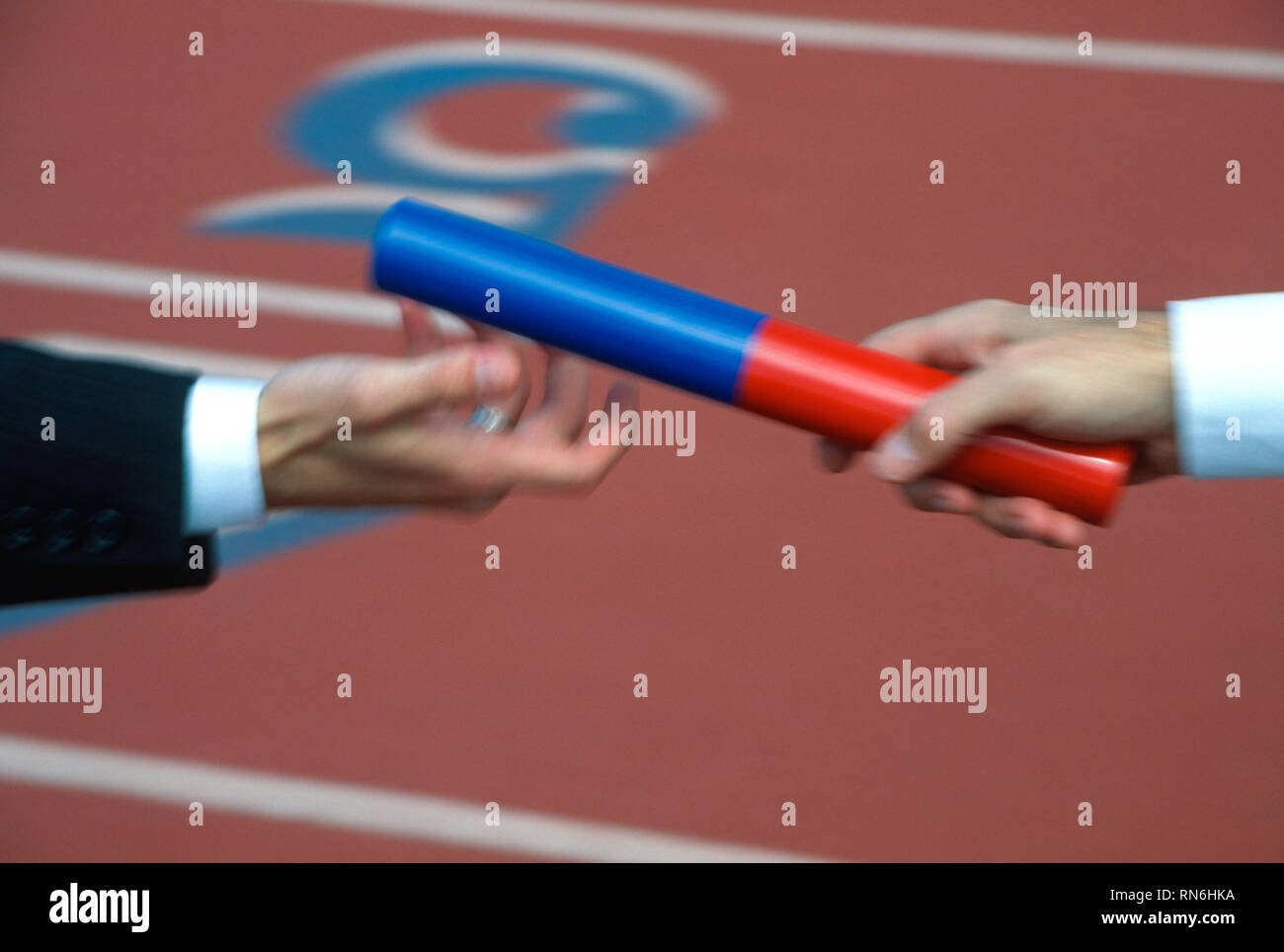 Businessmen passing the baton on running track, USA Stock Photo - Alamy