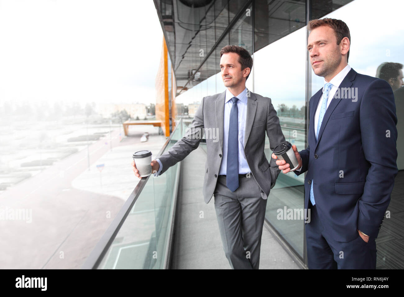 Business people having coffee break at the balcony of office building ...