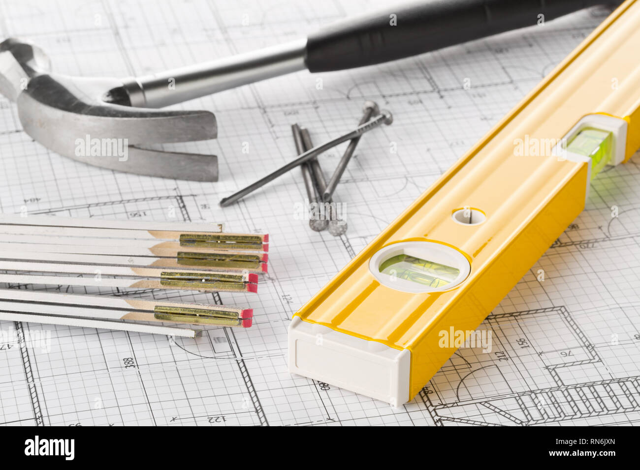Construction tools with hammer, nails, folding rule and level on ...
