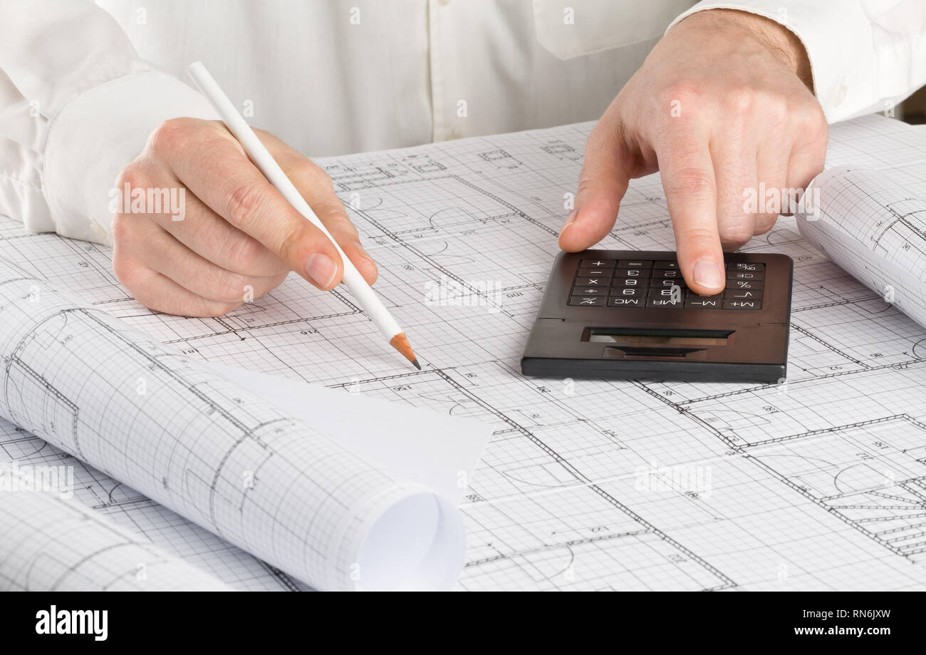 Architect using calculator on architectural blueprint house building ...