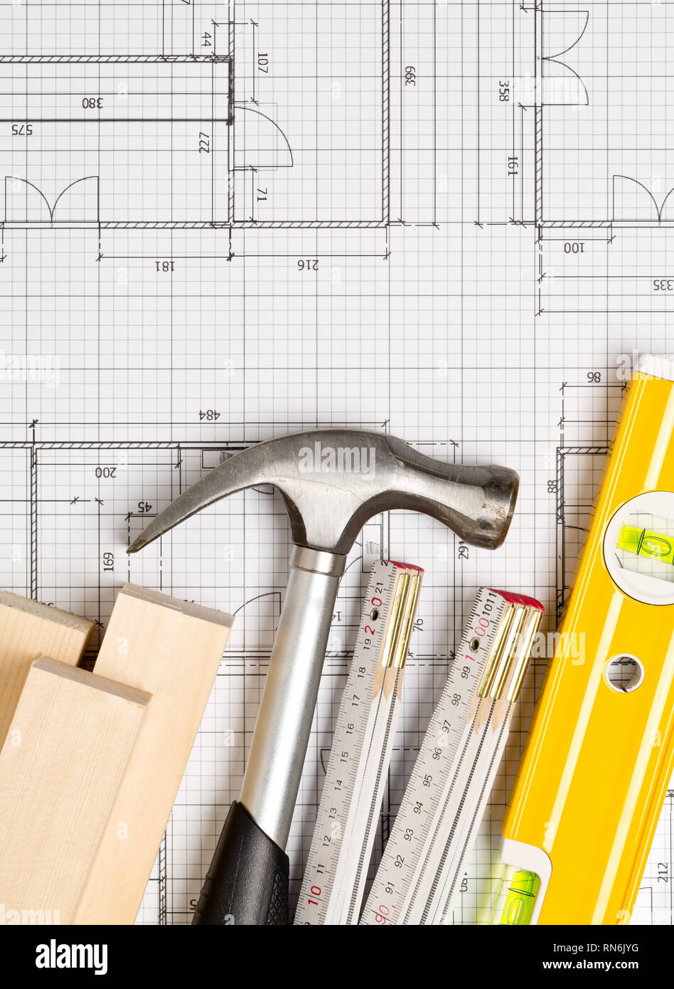 Construction tools and wooden strips on architectural blueprint house ...