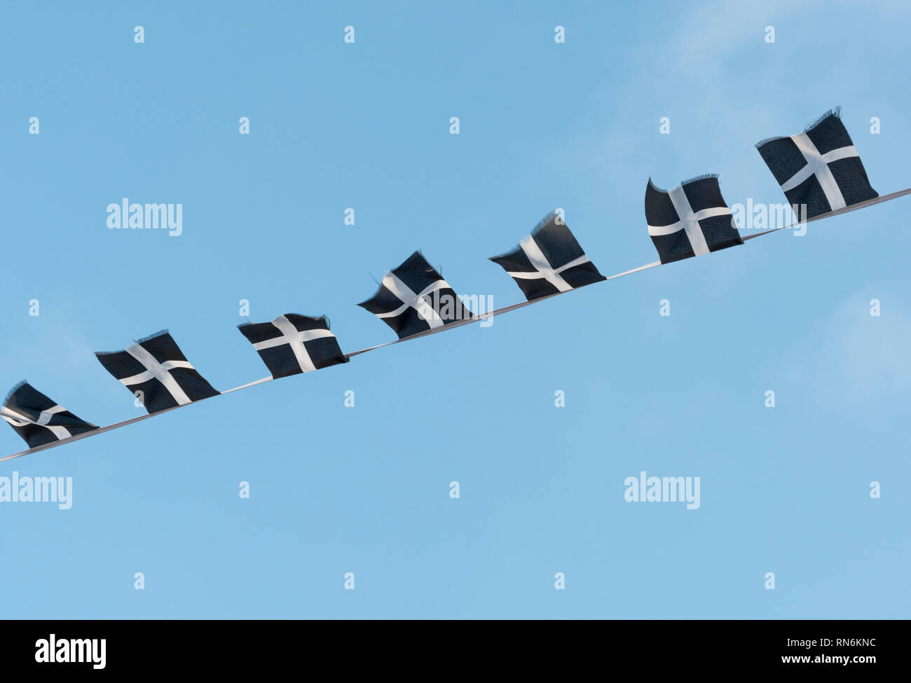 String of St. Piran's Cornwall / Cornish flags fluttering in the breeze ...