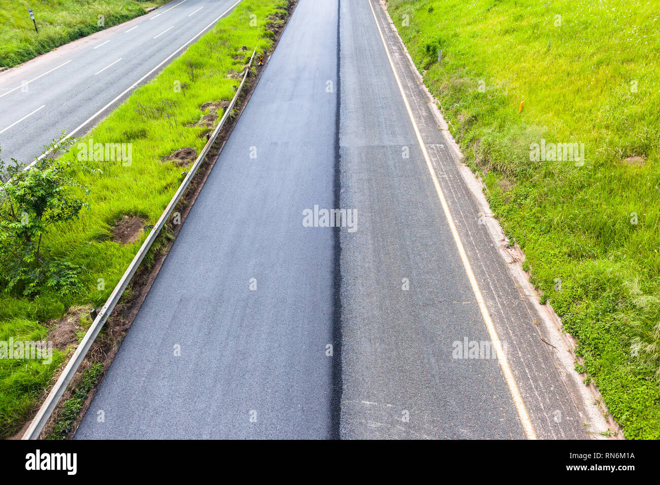 Road highway dual lanes with one lane resurfaced with new asphalt tar ...