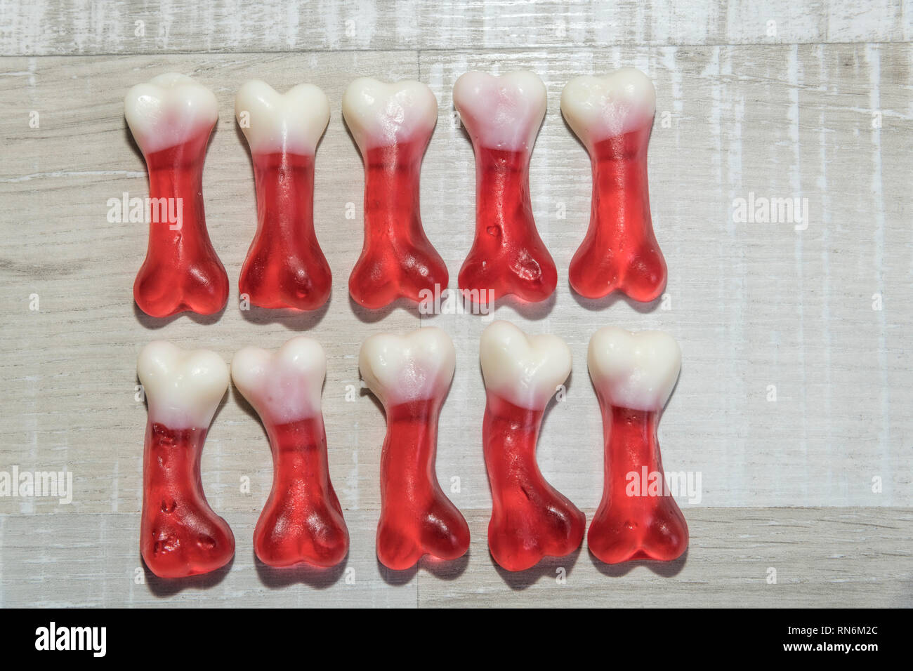 Pattern made of bone shaped jelly sweets isolated on a light wooden ...