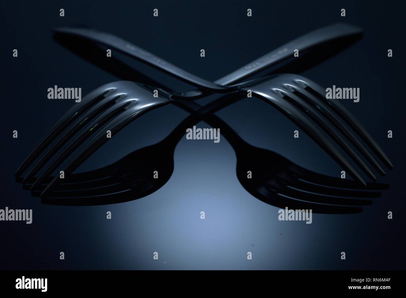 Image of two forks on the black mirror Stock Photo - Alamy